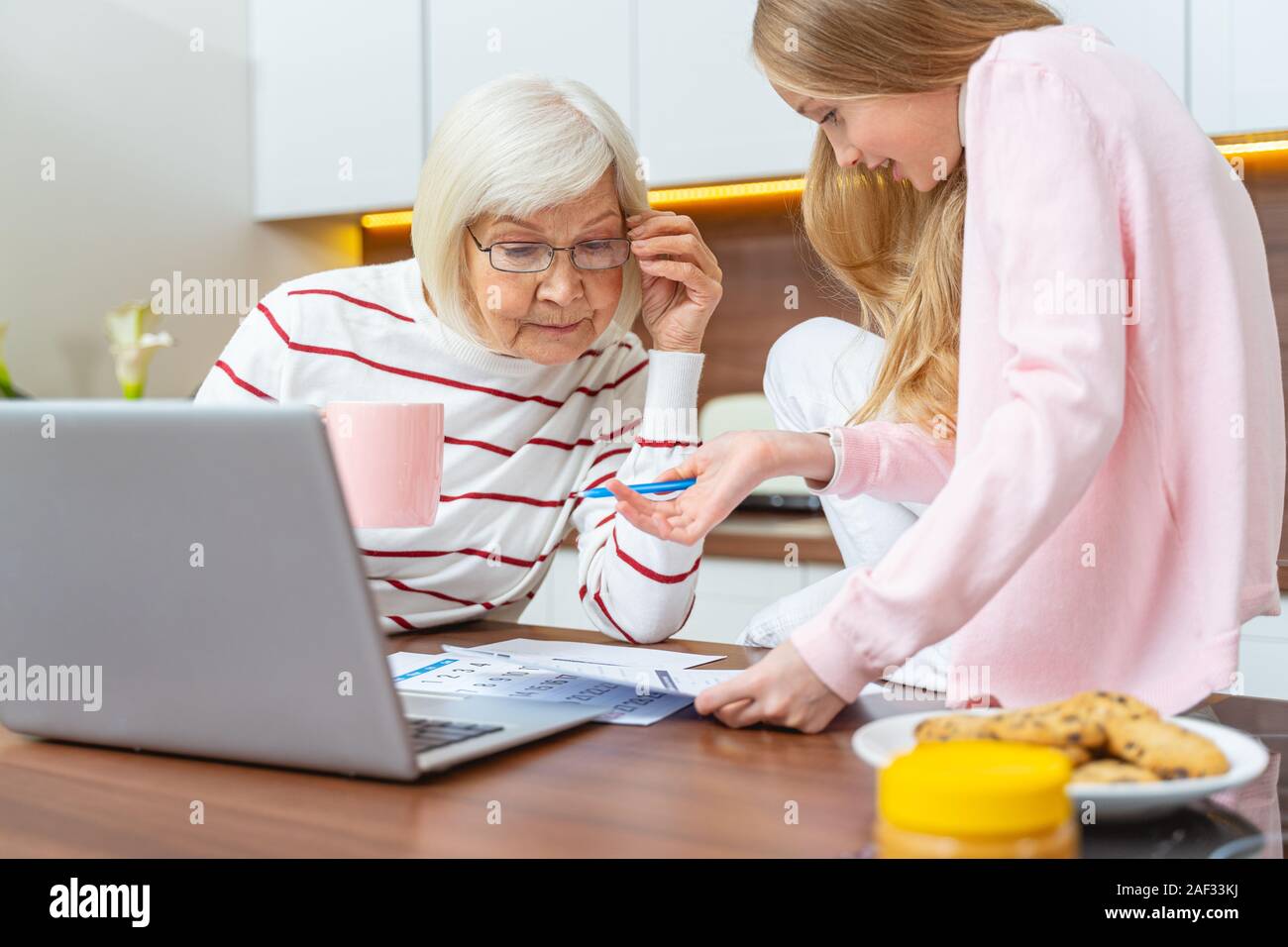 Focused elderly lady leaning over the document Stock Photo - Alamy
