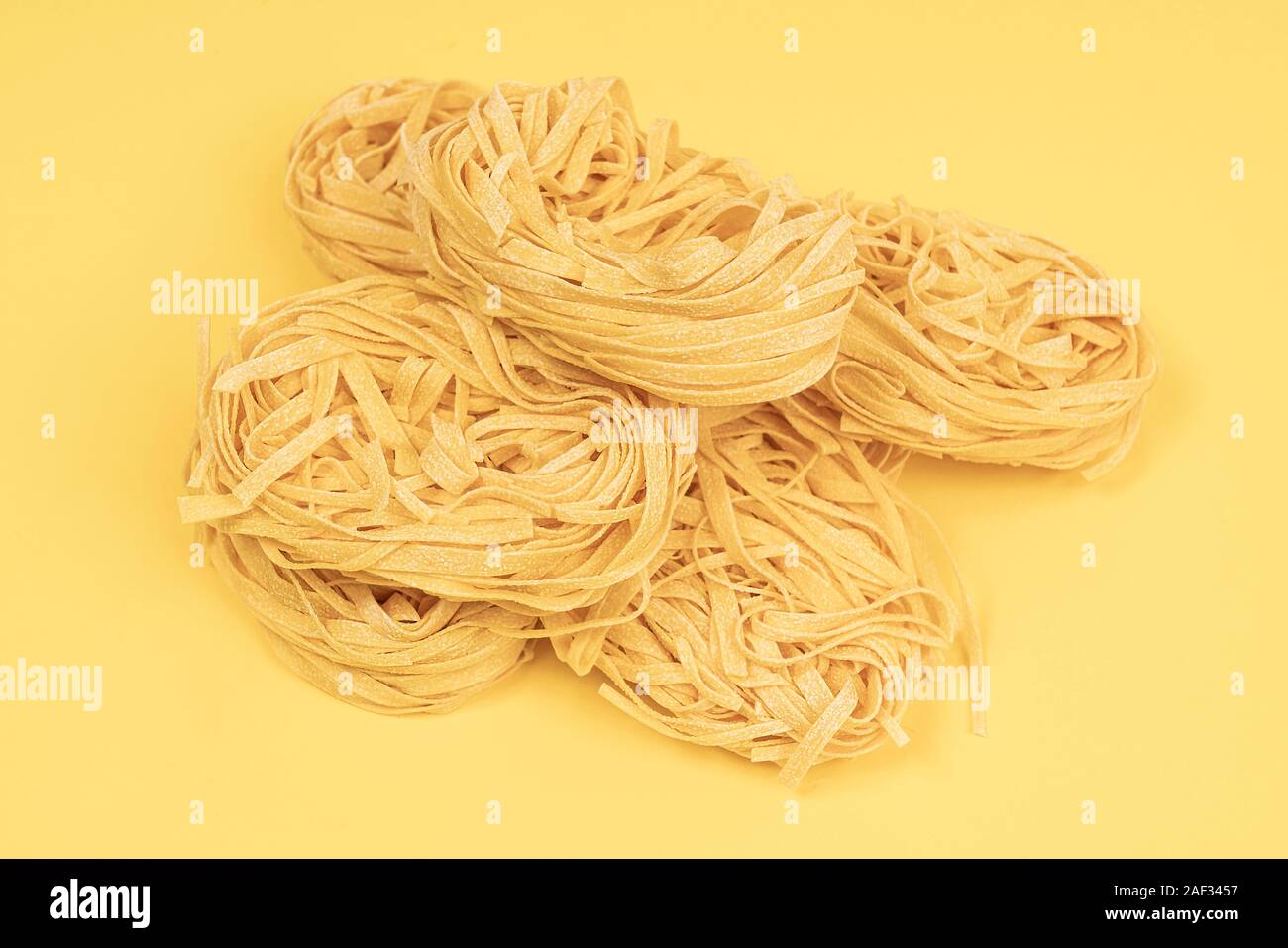 some "nests" of typical fresh egg pasta on a colored surface Stock ...