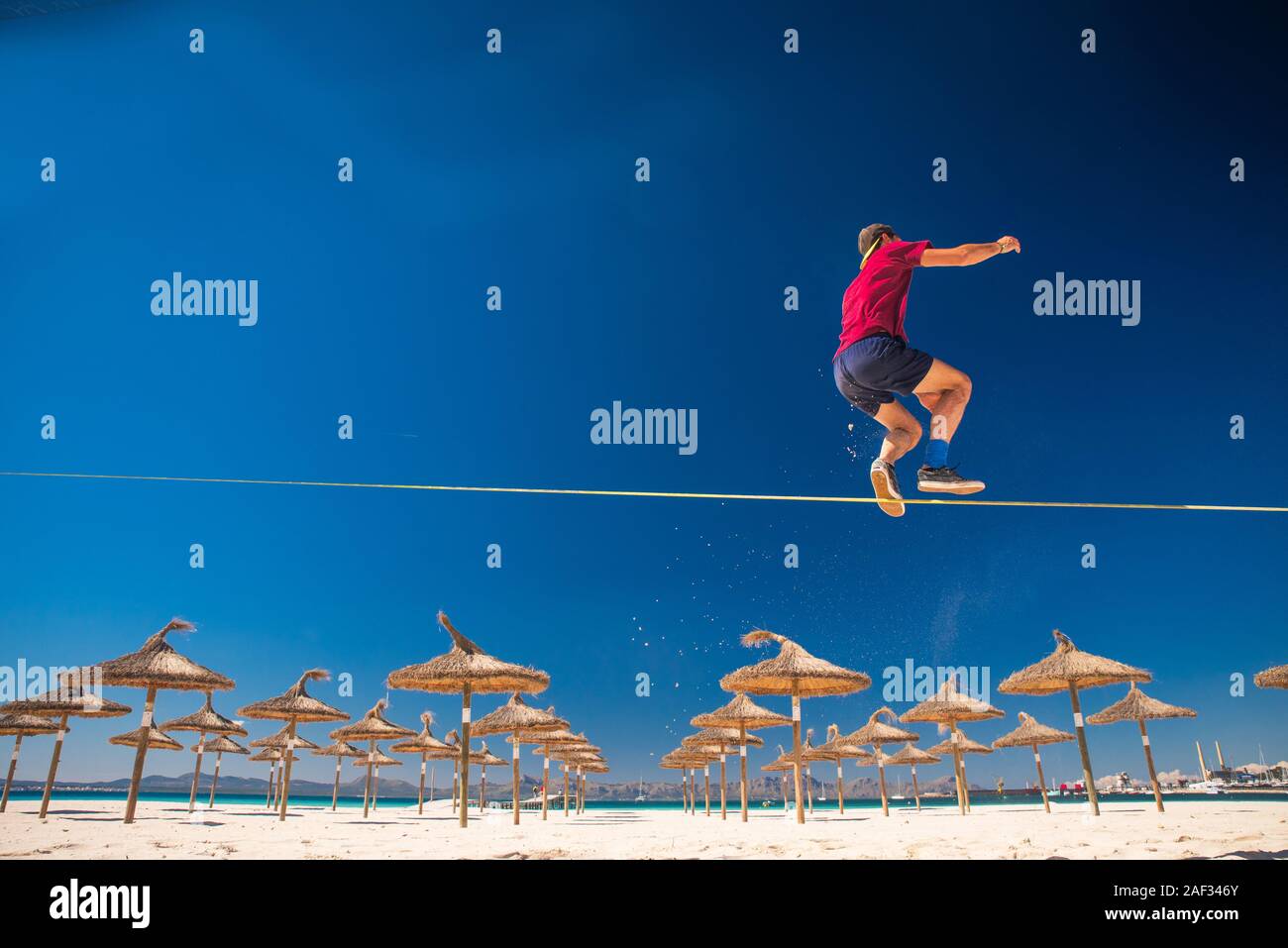 teenagers balance slackline on summer tropical beach Stock Photo - Alamy