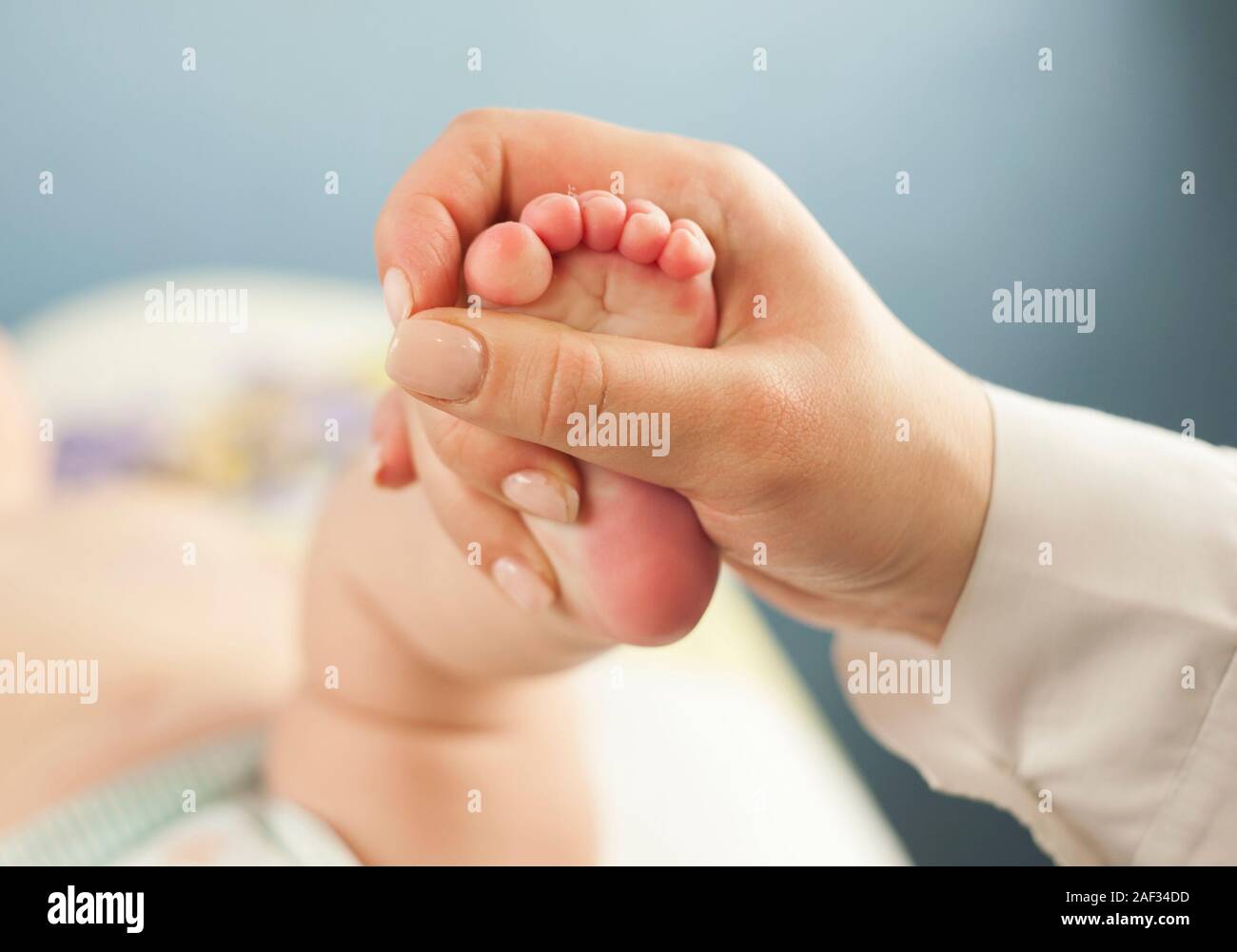 Mother holding her little baby's feet, close up.Concept skin ...