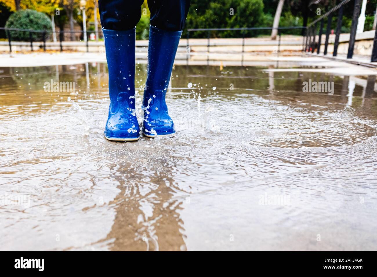Boy jumps in a puddle in the street after a rainy day Stock Photo - Alamy