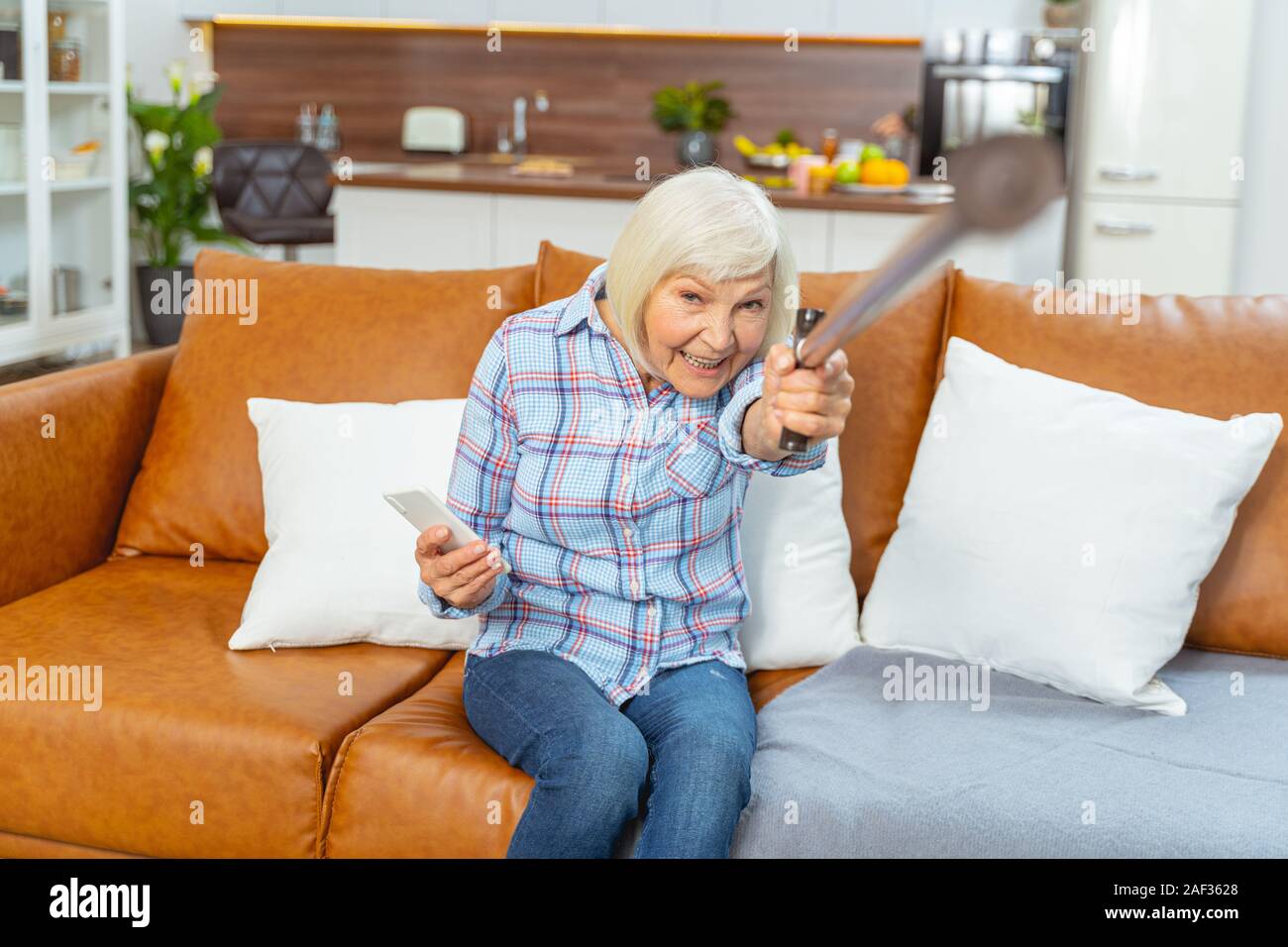 Cheerful aged Caucasian woman lifting her cane Stock Photo - Alamy