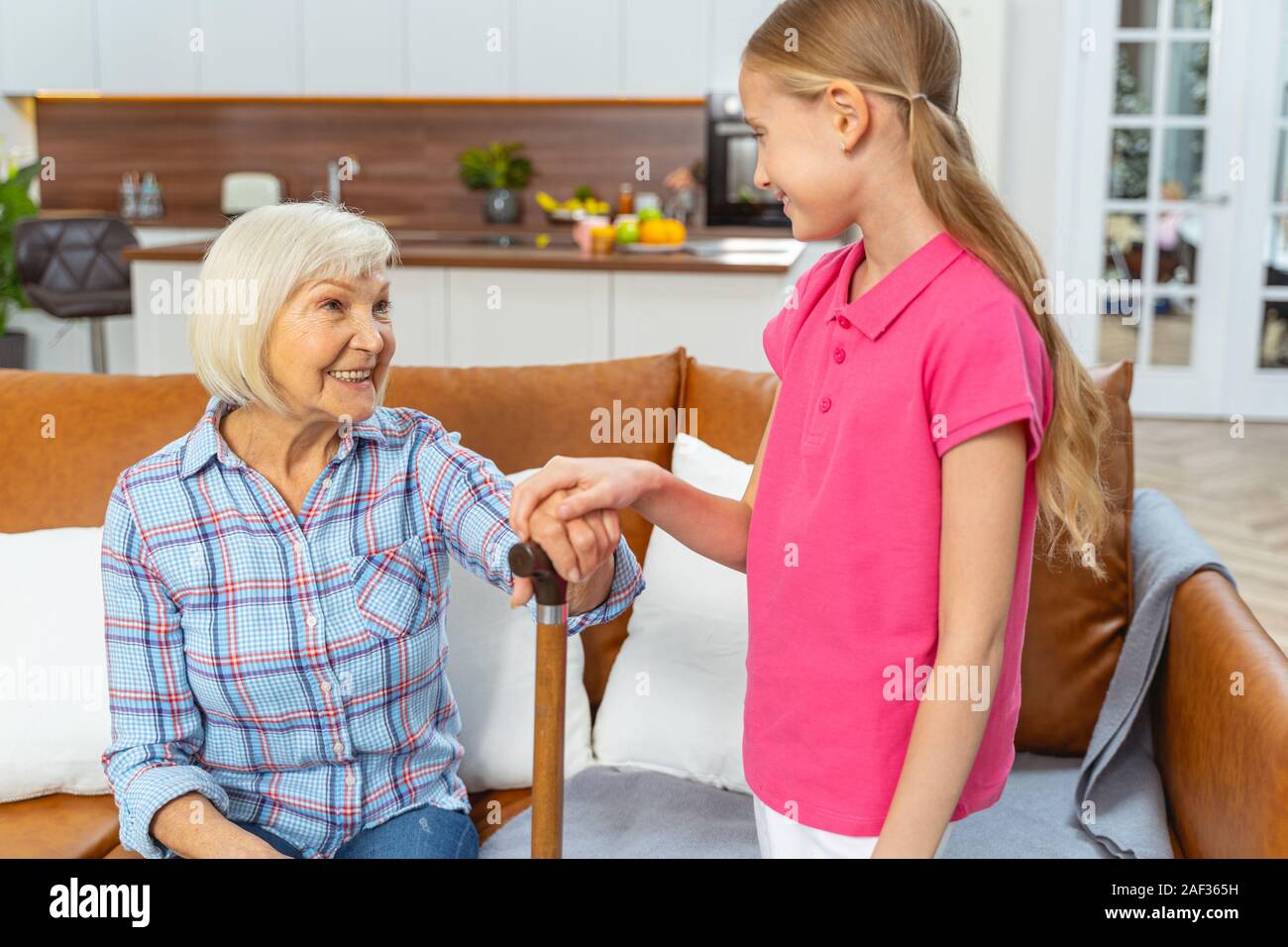 Caring young girl touching her grandmother hand Stock Photo - Alamy