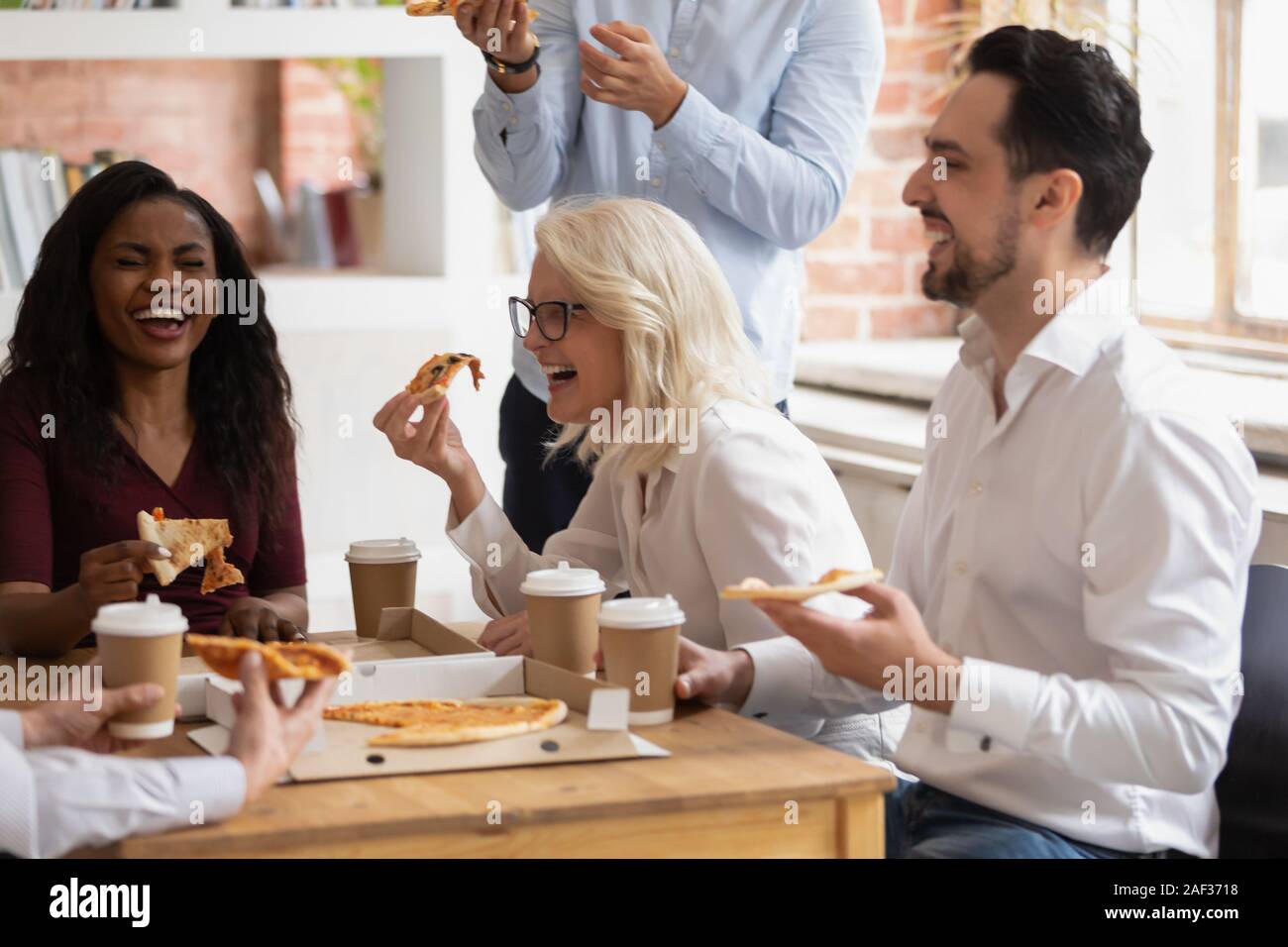 Multi Racial Colleagues Eat Pizza Enjoy Break During Working Day Stock