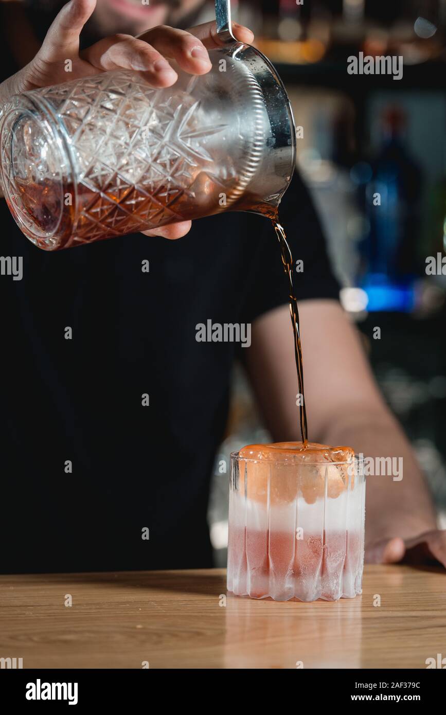 Boulevardie cocktail on a bar desk. Bartender pouring alcohol Stock ...
