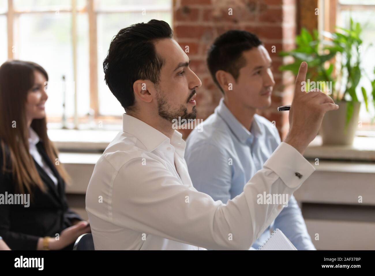 Middle eastern man raising hand to ask question at seminar Stock Photo ...