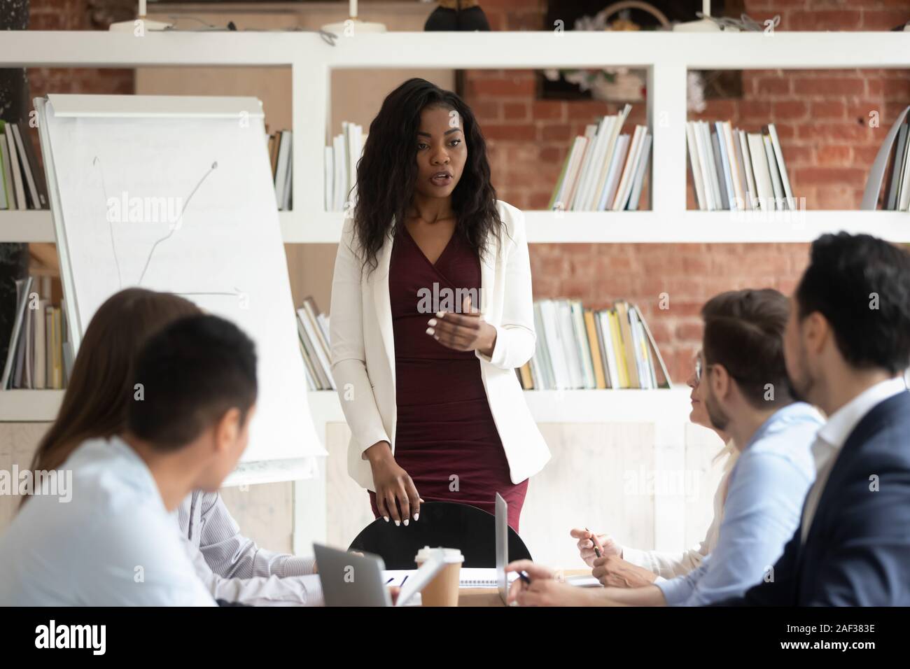 Staff sit at desk listening company boss african businesswoman speech ...