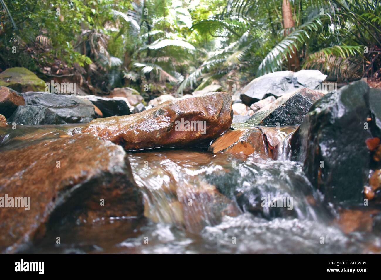 water coming down from the middle of the rocks Stock Photo - Alamy