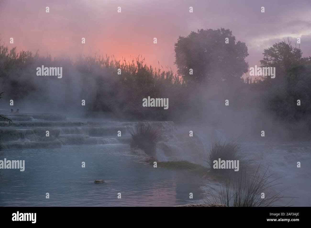 Steam of the sulphurous water ascents over the white cascades of the ...