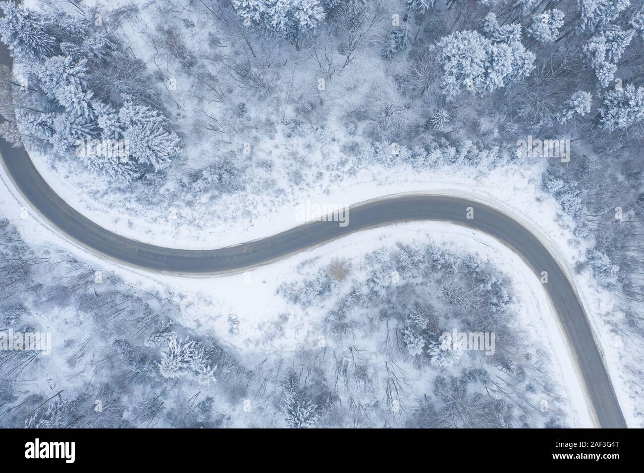 Aerial view of winter road and forest with snow covered trees, top view ...