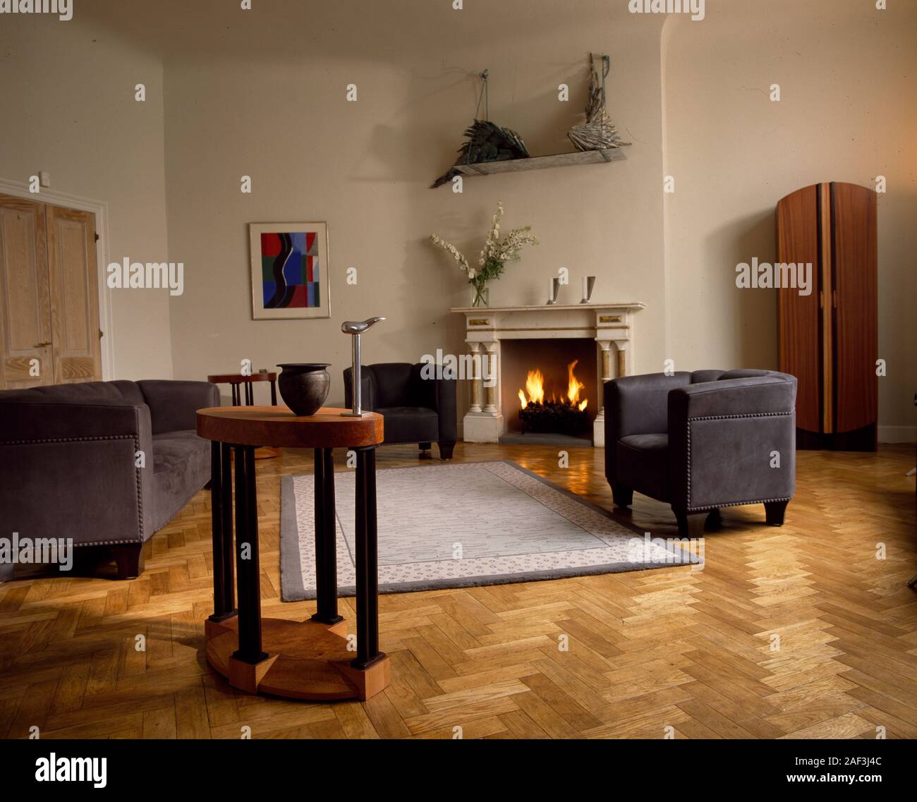 Large parquet floored living room with open fire Stock Photo - Alamy