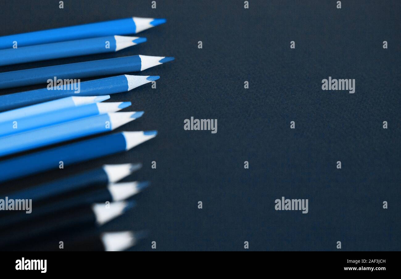 Colored pencils against dark blue background. Close up and selective ...