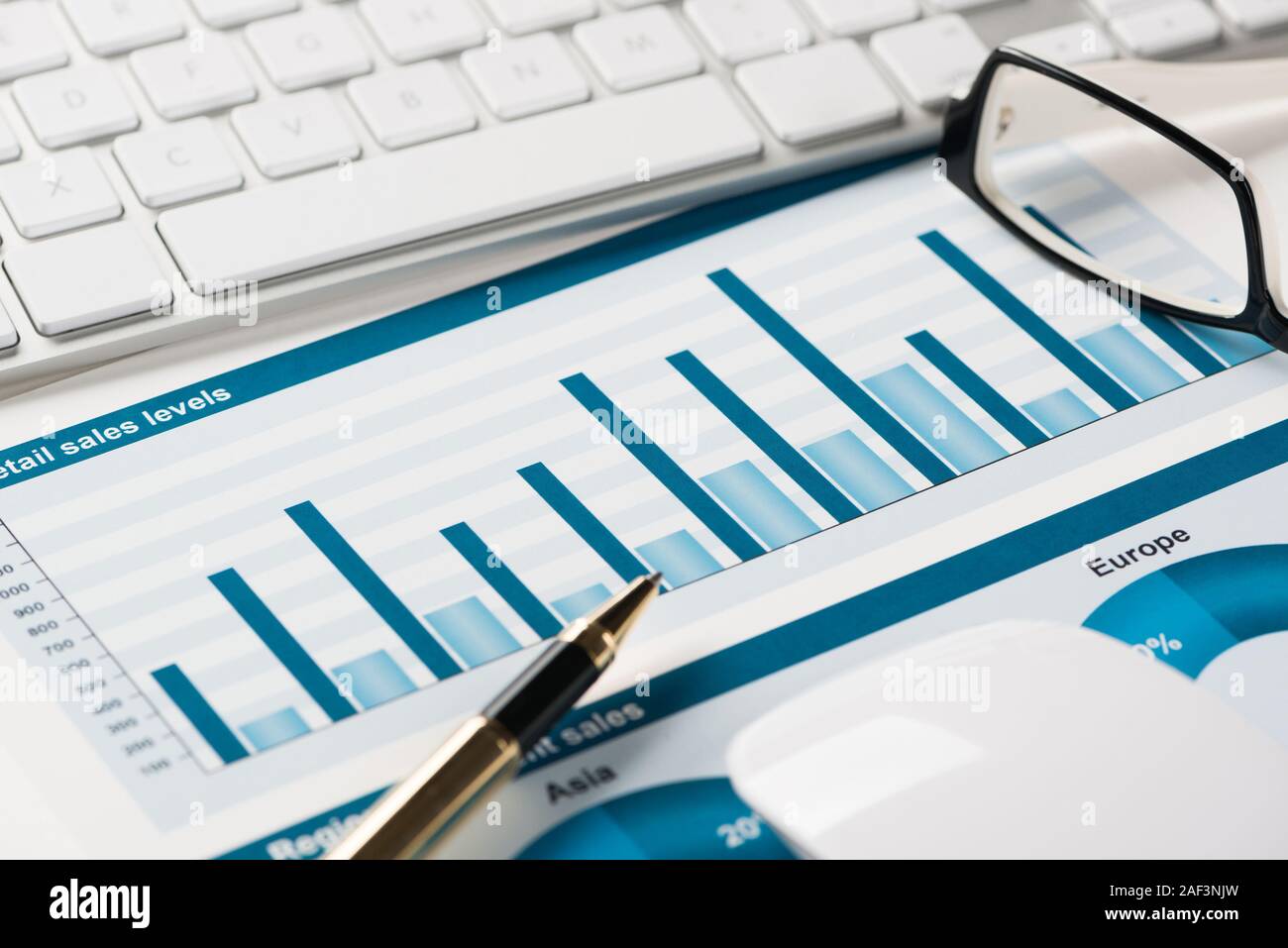 Business workplace with keyboard mouse and papers with graphs and ...