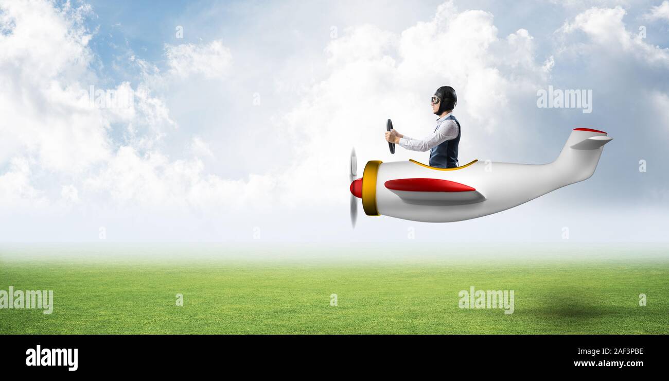 Happy aviator driving small propeller plane on background of natural ...