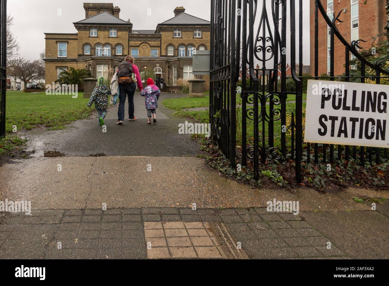 A young woman with small children going to vote at a Polling Station ...