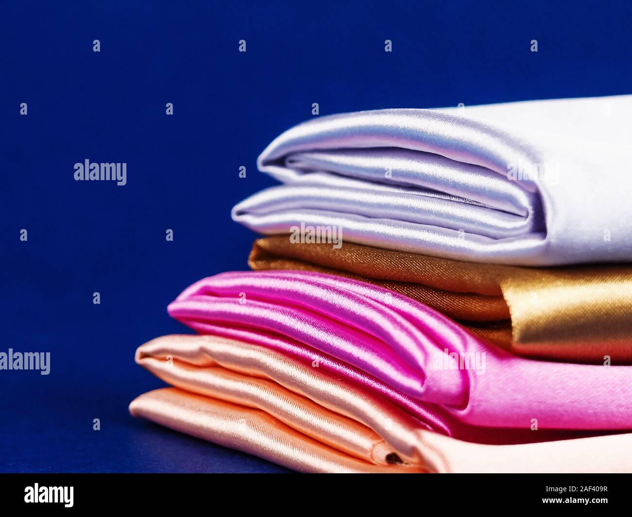 rolls of silk of different colors folded stack. colorful fabric silk ...