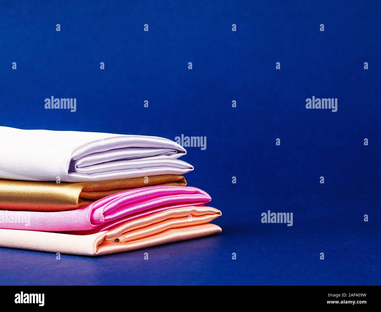 rolls of silk of different colors folded stack. colorful fabric silk ...
