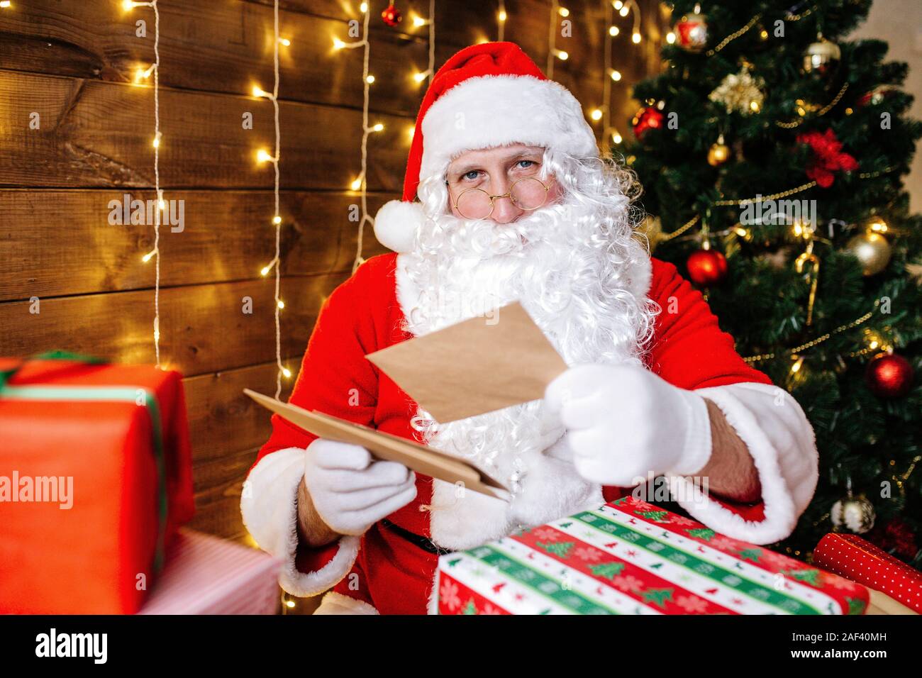Merry Christmas and Happy Holidays. Santa Clause is preparing gifts for ...