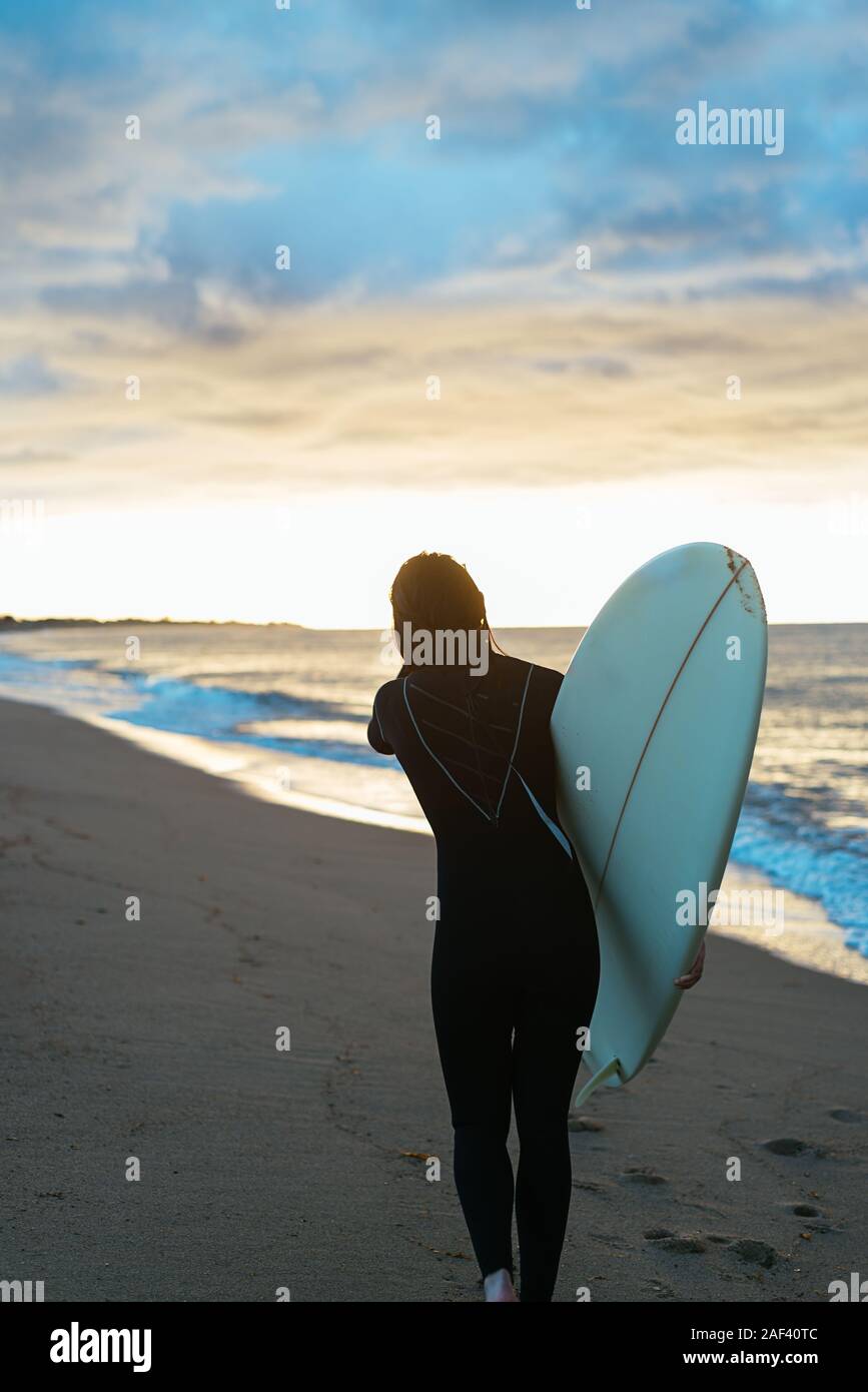 Young beautiful surfer woman running to the waves Stock Photo - Alamy