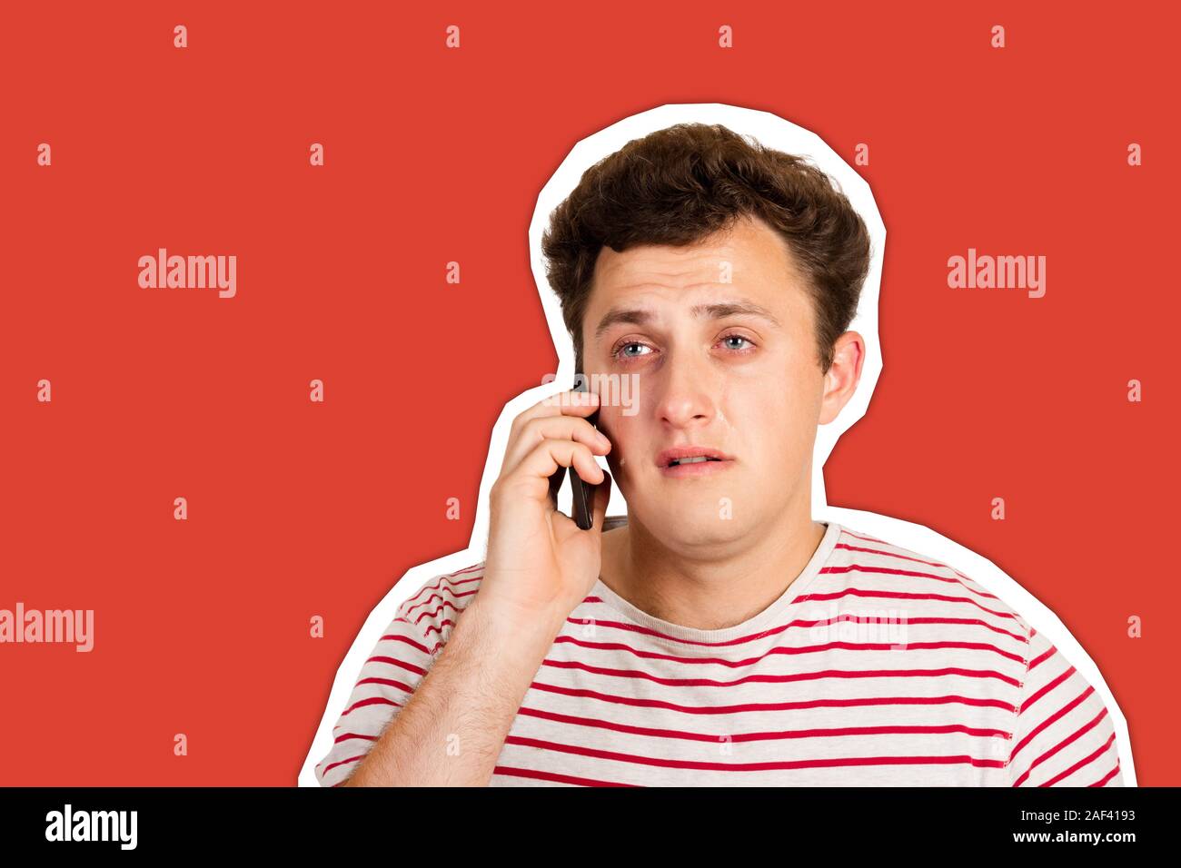 Young man crying over the bad news he is receiving on his phone ...