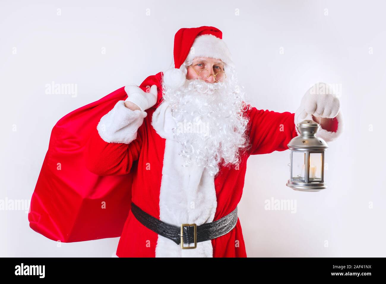 Santa Claus carrying big red bag full of gifts and light the road on ...