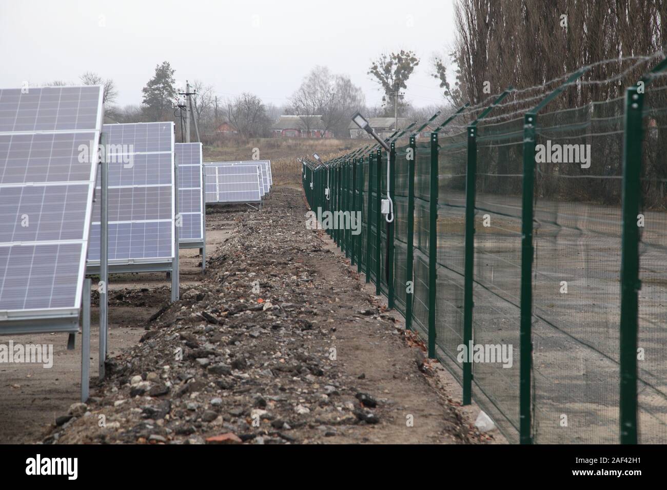 Solar panels near a rural road. Solar panel produces green ...