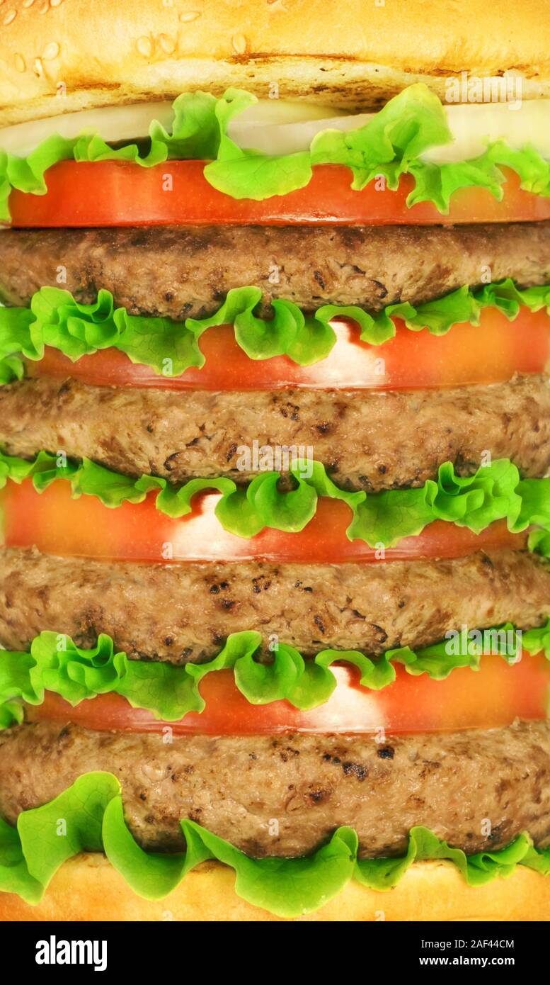 Over sized stack of beef burgers with salad filling Stock Photo - Alamy
