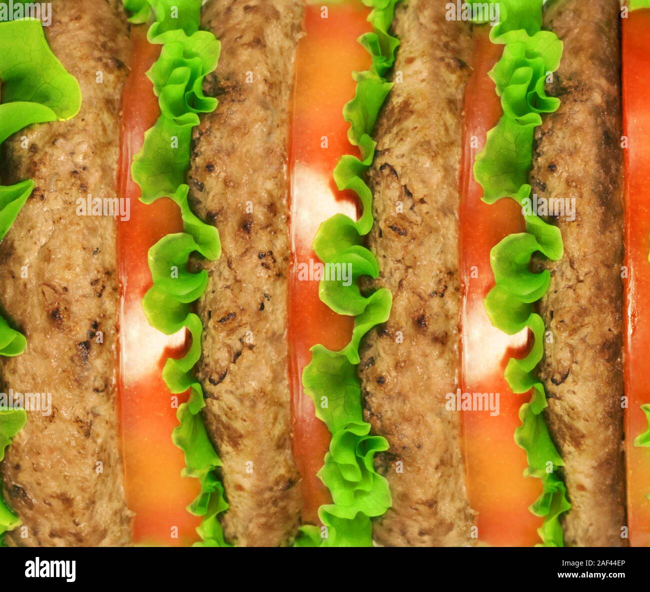 Over sized stack of beef burgers with salad filling Stock Photo - Alamy