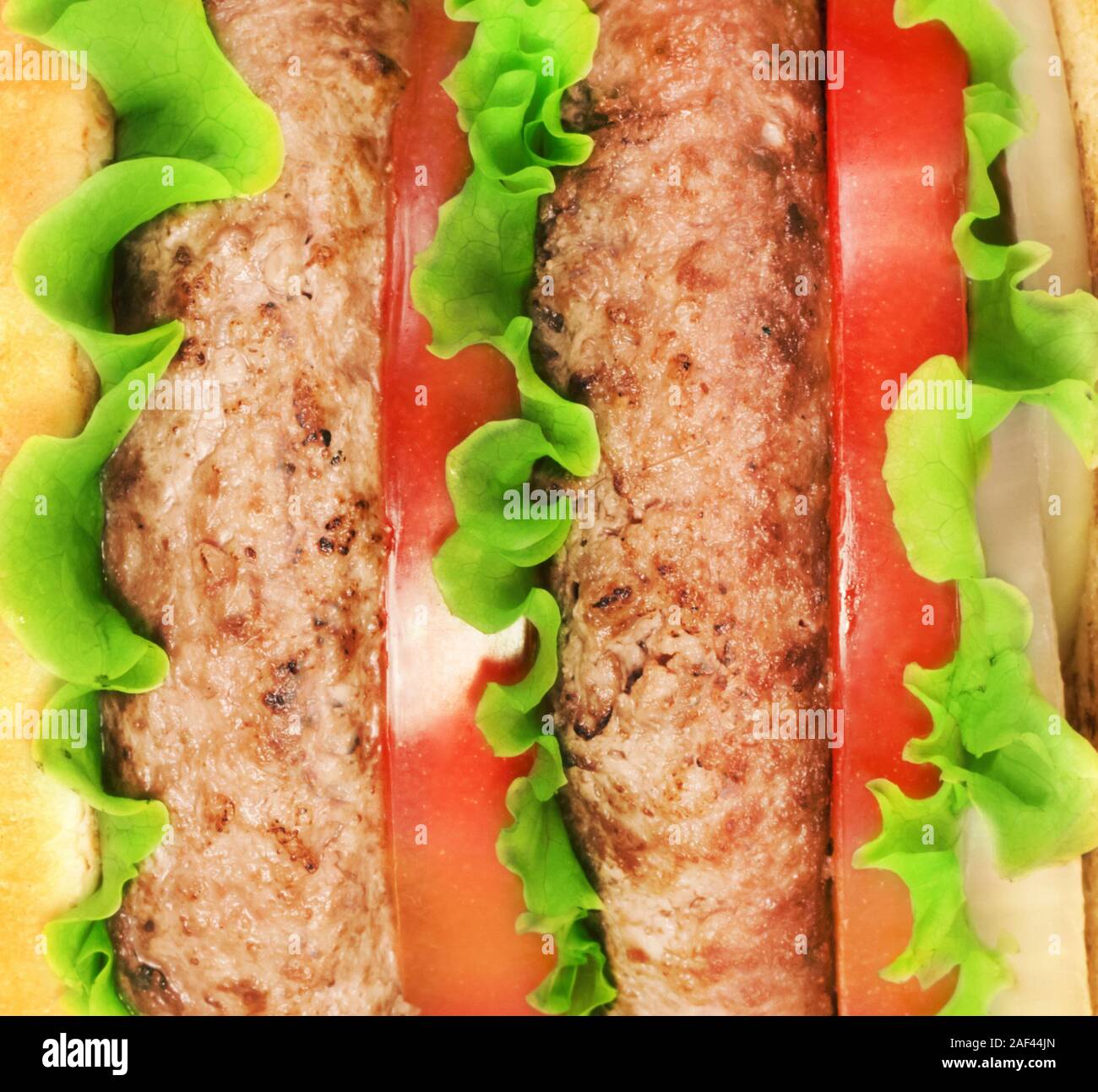Over sized stack of beef burgers with salad filling Stock Photo - Alamy