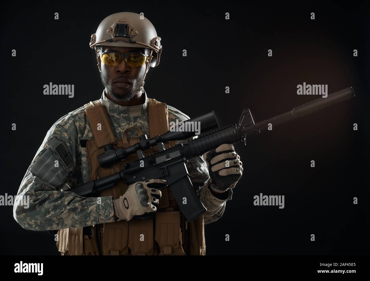 Seriously American soldier in uniform holding modern weapon in hands ...