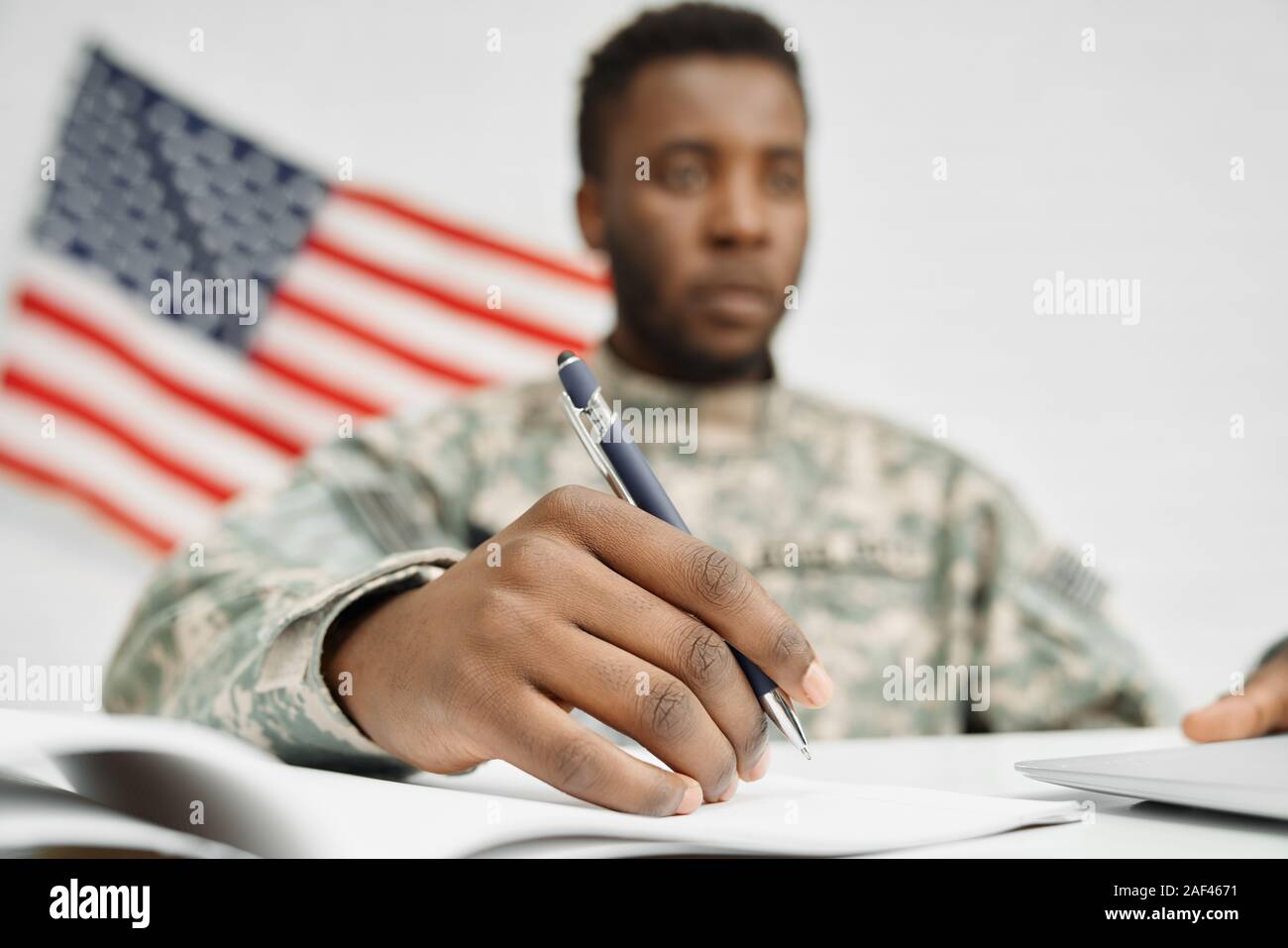 Close up of male soldier hand holding pen and writing document ...