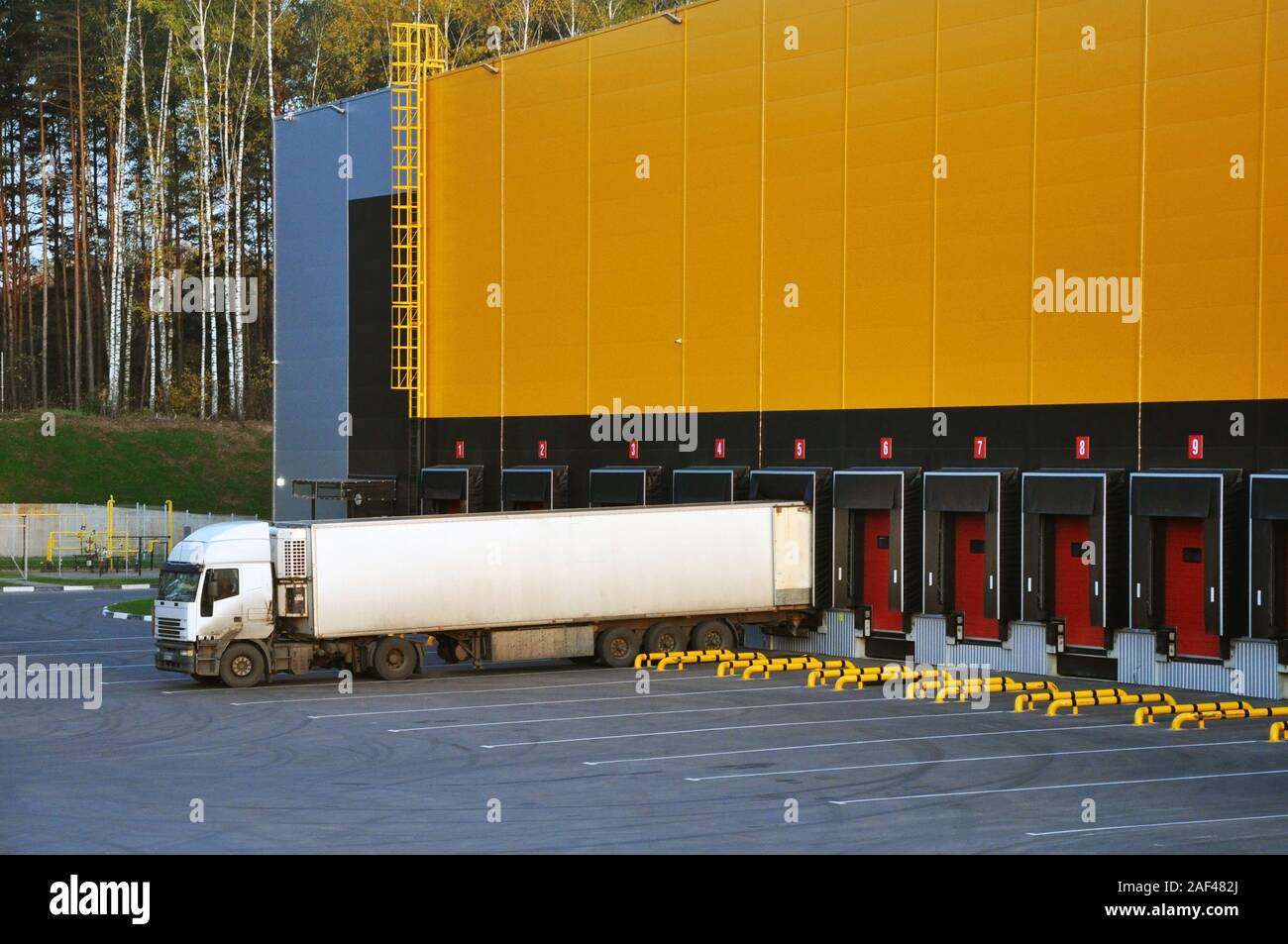 Unloading trucks at a modern warehouse complex. Logistics Stock Photo ...