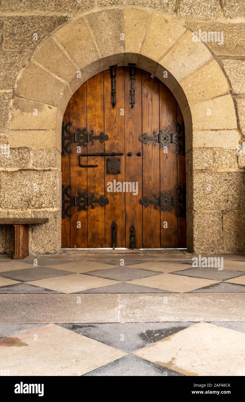 Solid wood and reinforced arched door inside historic monastery in ...