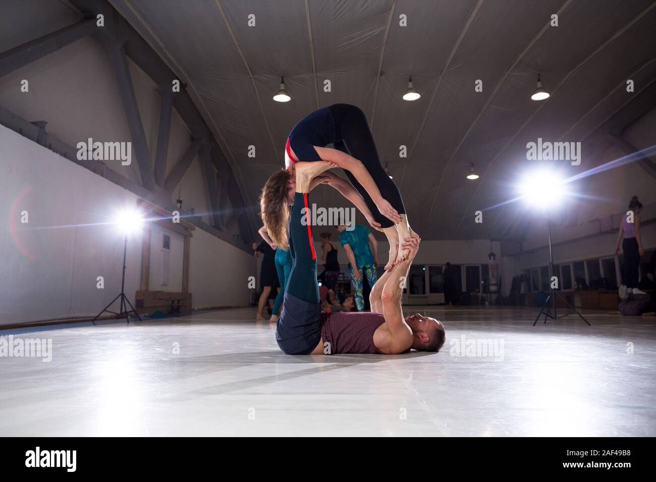 Couple does acroyoga, physical practice yoga and acrobatics. Balance ...