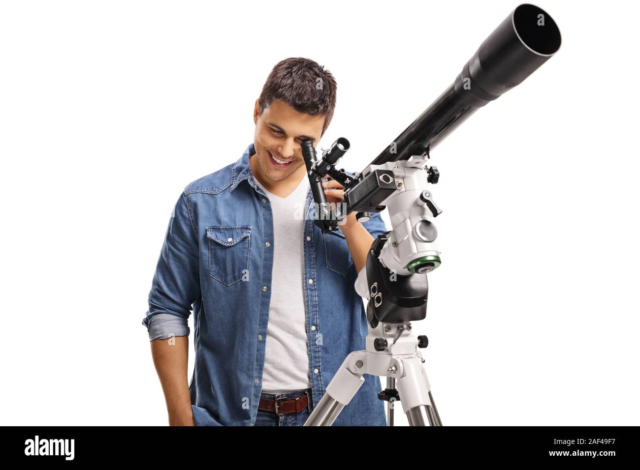 Young man looking through a telescope isolated on white background ...