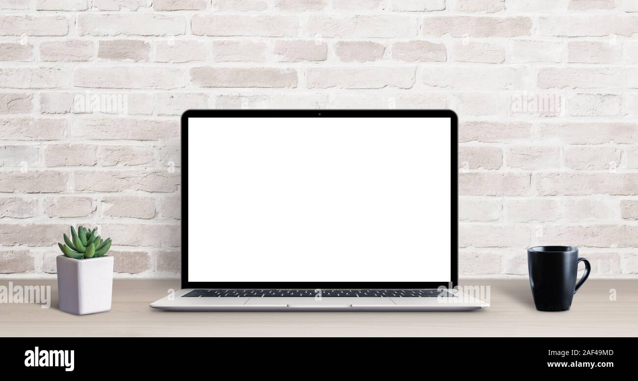 Laptop mockup on simple, clean desk with brick wall in background ...