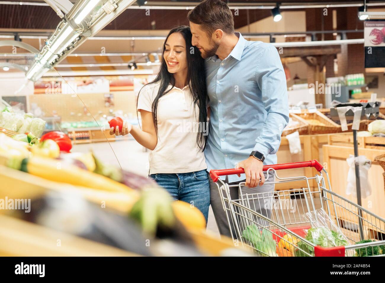 Daily Shopping. Couple in the supermarket with cart together hugging ...