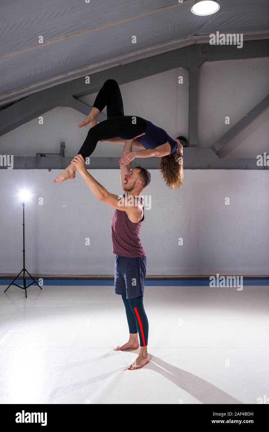 The theme of Acroyoga and Yoga Poses. A pair of two men and a woman ...