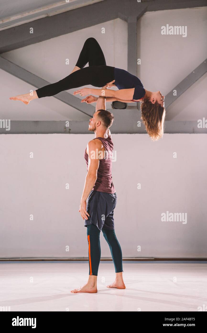 The theme of Acroyoga and Yoga Poses. A pair of two men and a woman ...