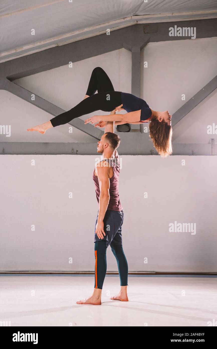 The theme of Acroyoga and Yoga Poses. A pair of two men and a woman ...
