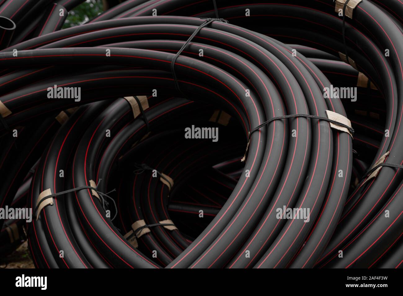 Black rubber or plastic pipes with a red lines as a construction ...