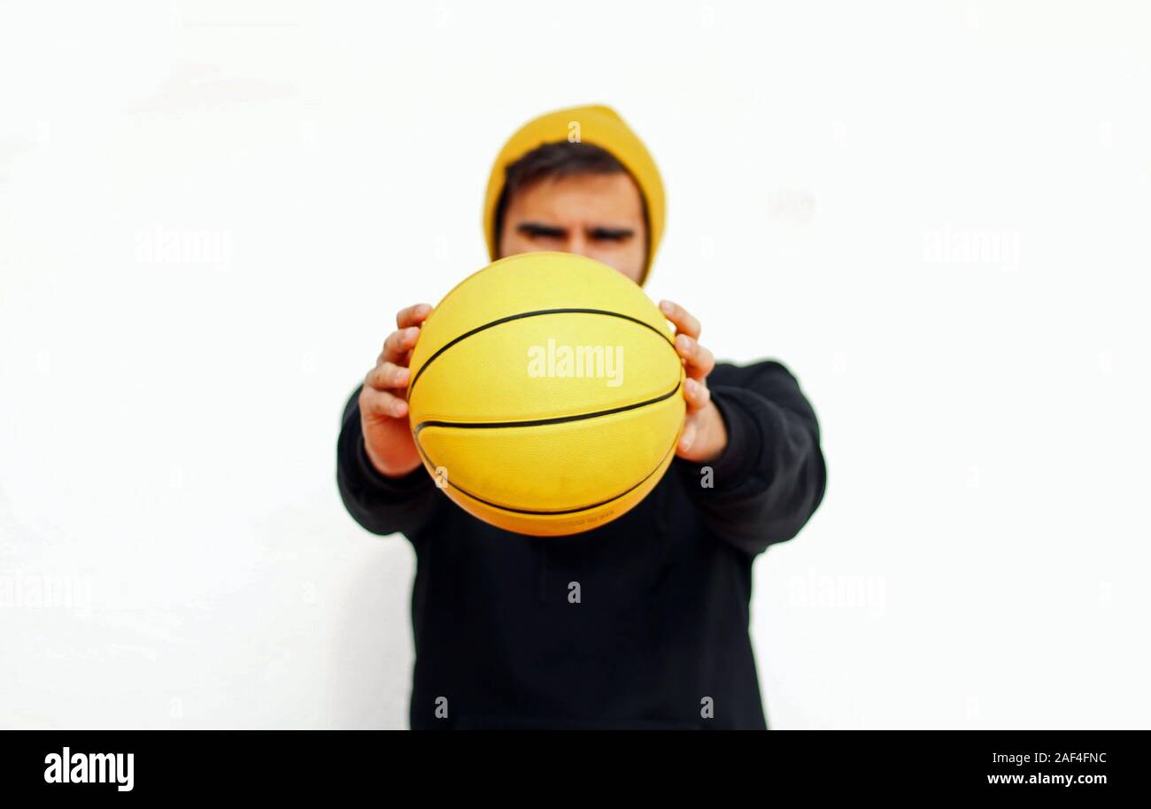 Basketball player dressed in black showing a yellow basketball. Sport ...