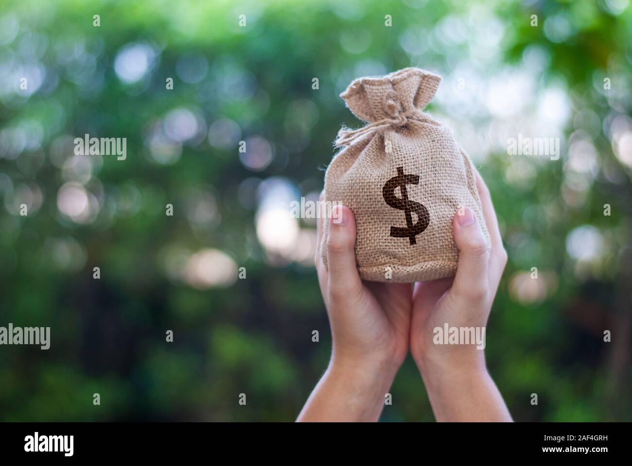 Hands holding money bags, saving money for business growth and future ...