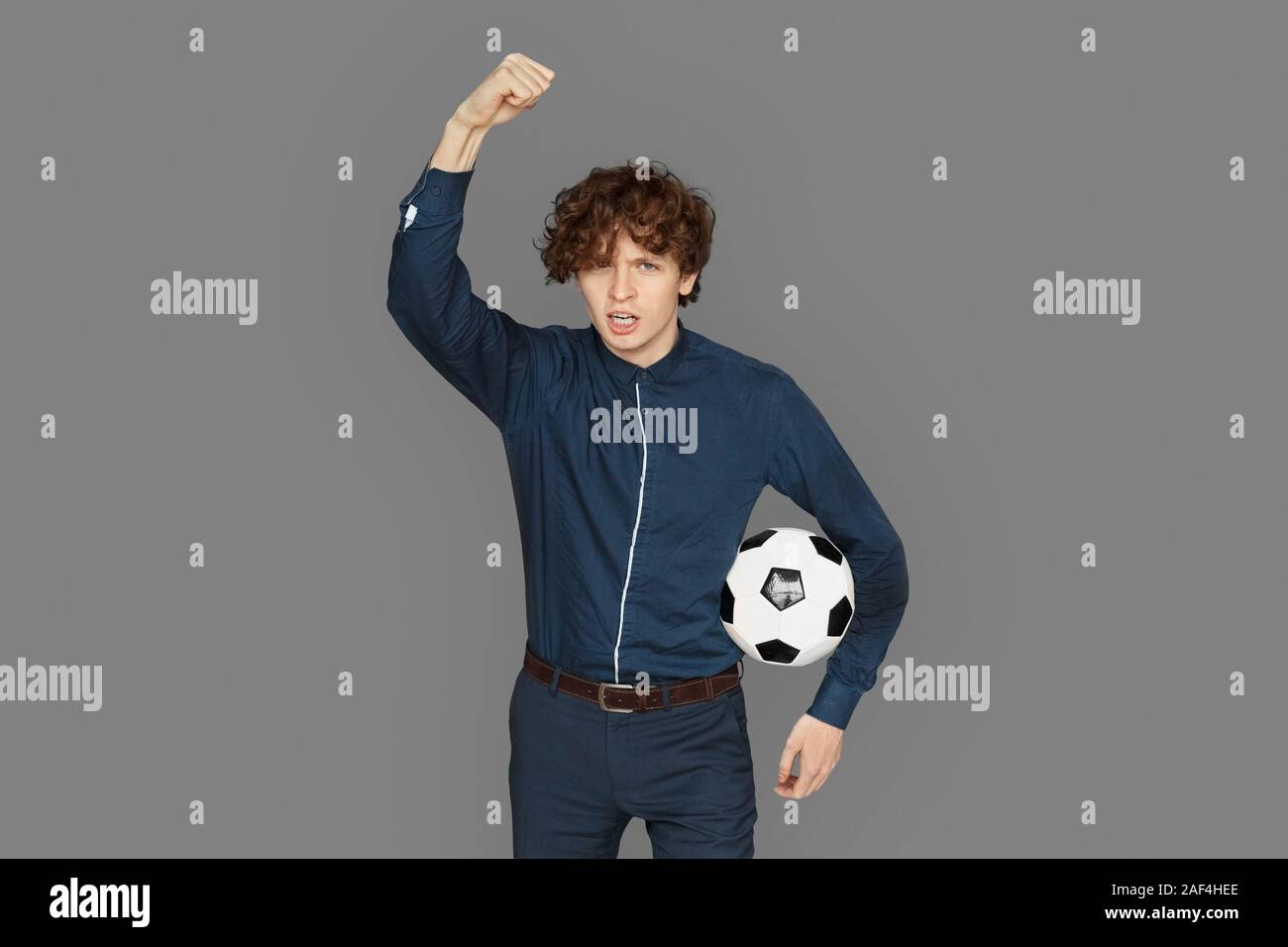 Sporty Lifestyle. Teenager boy standing isolated on grey with ball hand ...