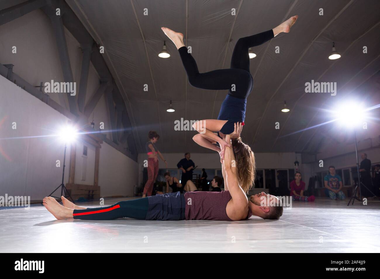 Couple does acroyoga, physical practice yoga and acrobatics. Balance ...