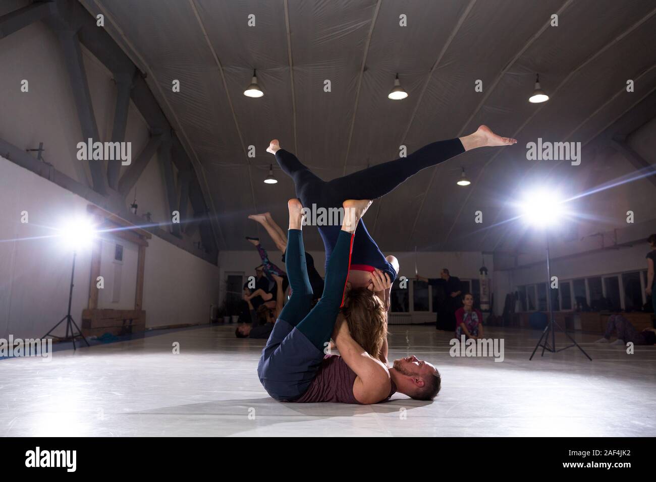 Couple does acroyoga, physical practice yoga and acrobatics. Balance ...