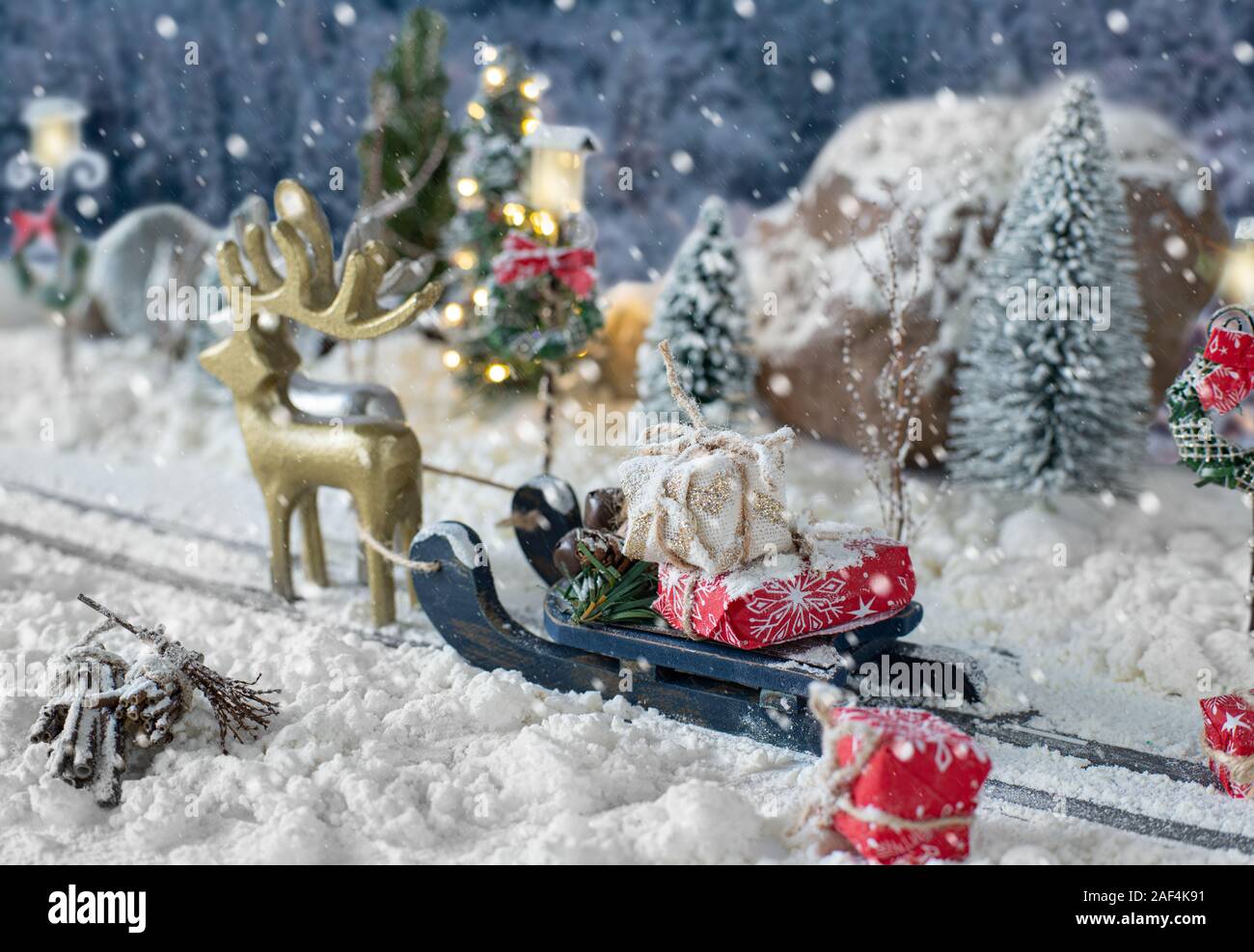 Sled loaded of gifts and miniature car carrying a christmas tree on ...