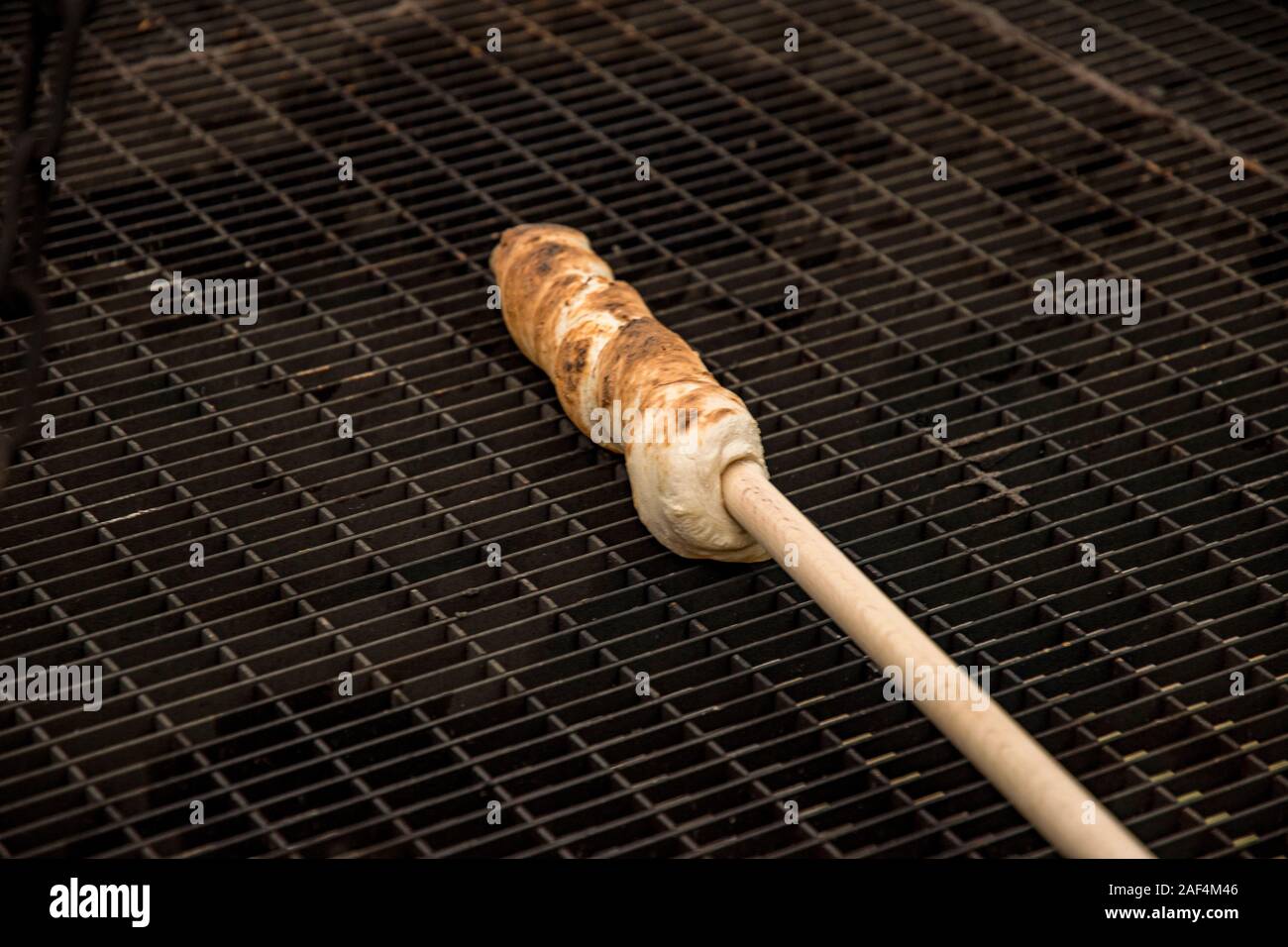 Preparing stick bread in the embers of a campfire Stock Photo - Alamy