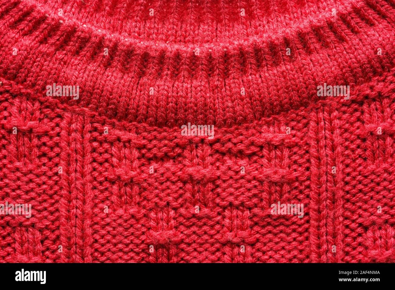 The texture of a knitted sweater. Red pattern. Facial surface ...
