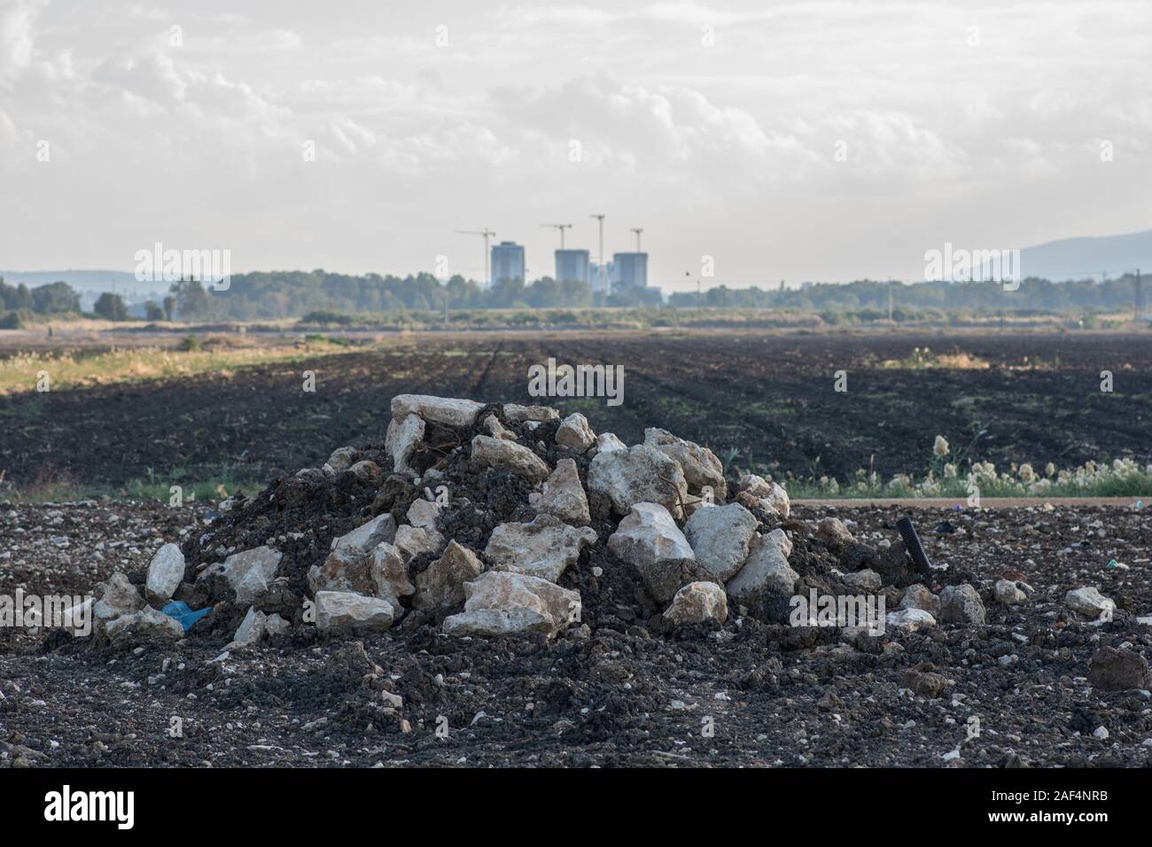 Little pile of rocks and soil, in the middle of a field, mountains in ...